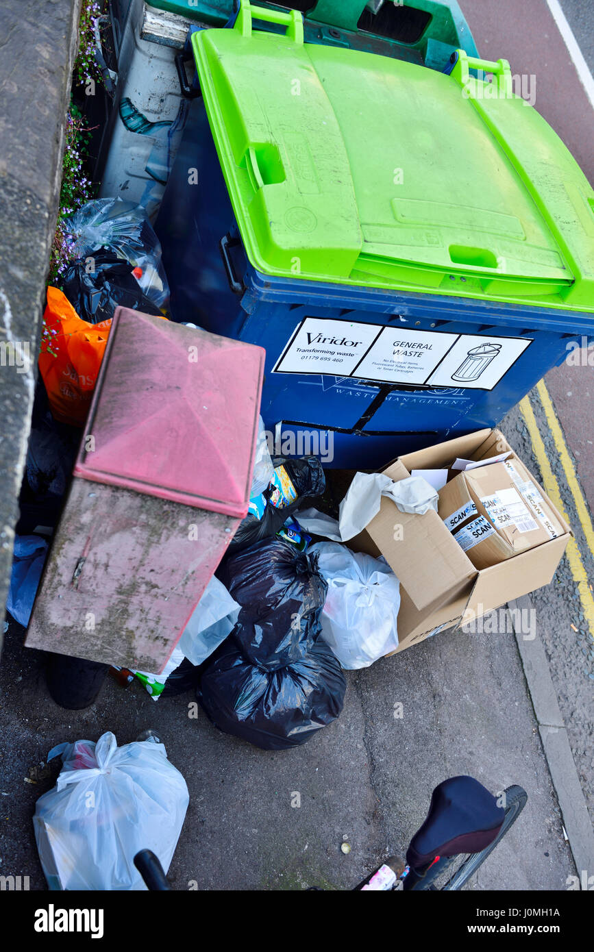 Rubbish piled outside next to large refuse container Stock Photo - Alamy
