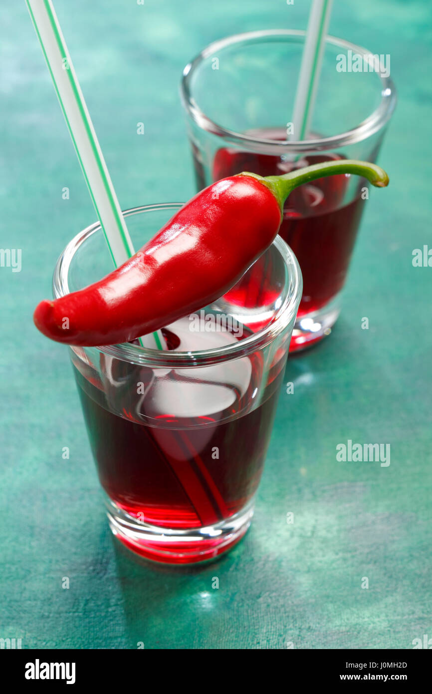 Red drinks in glass with a drinking straw and hot chili pepper Stock ...