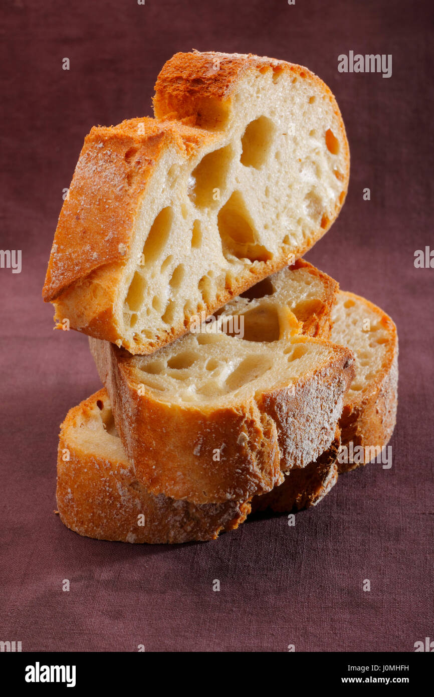 Sliced italian bread on brown painted textile background Stock Photo ...