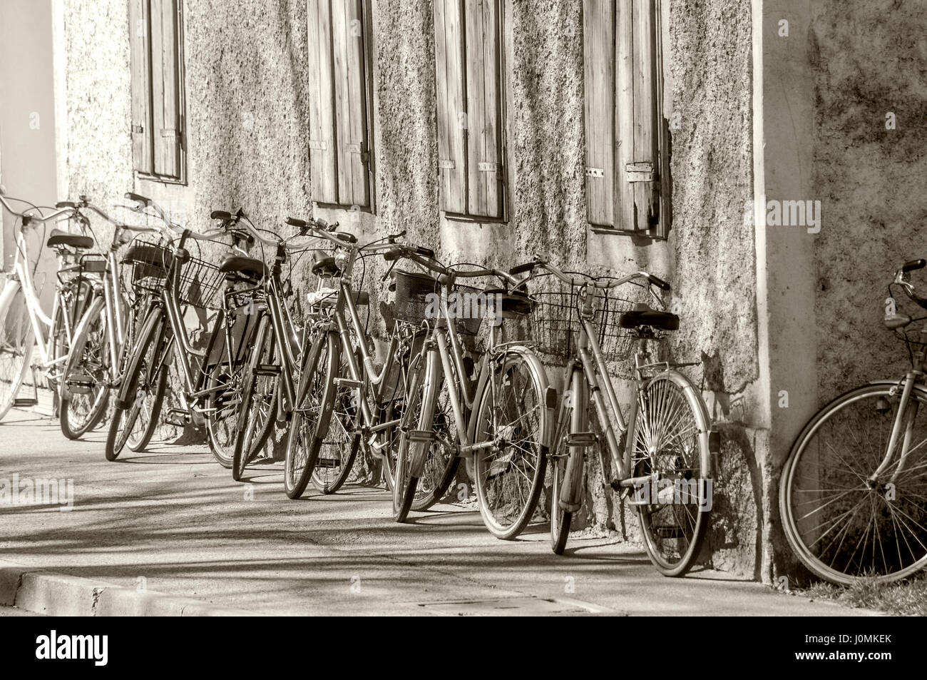 black and white photo of cycles waiting for the owners to finish mess ...