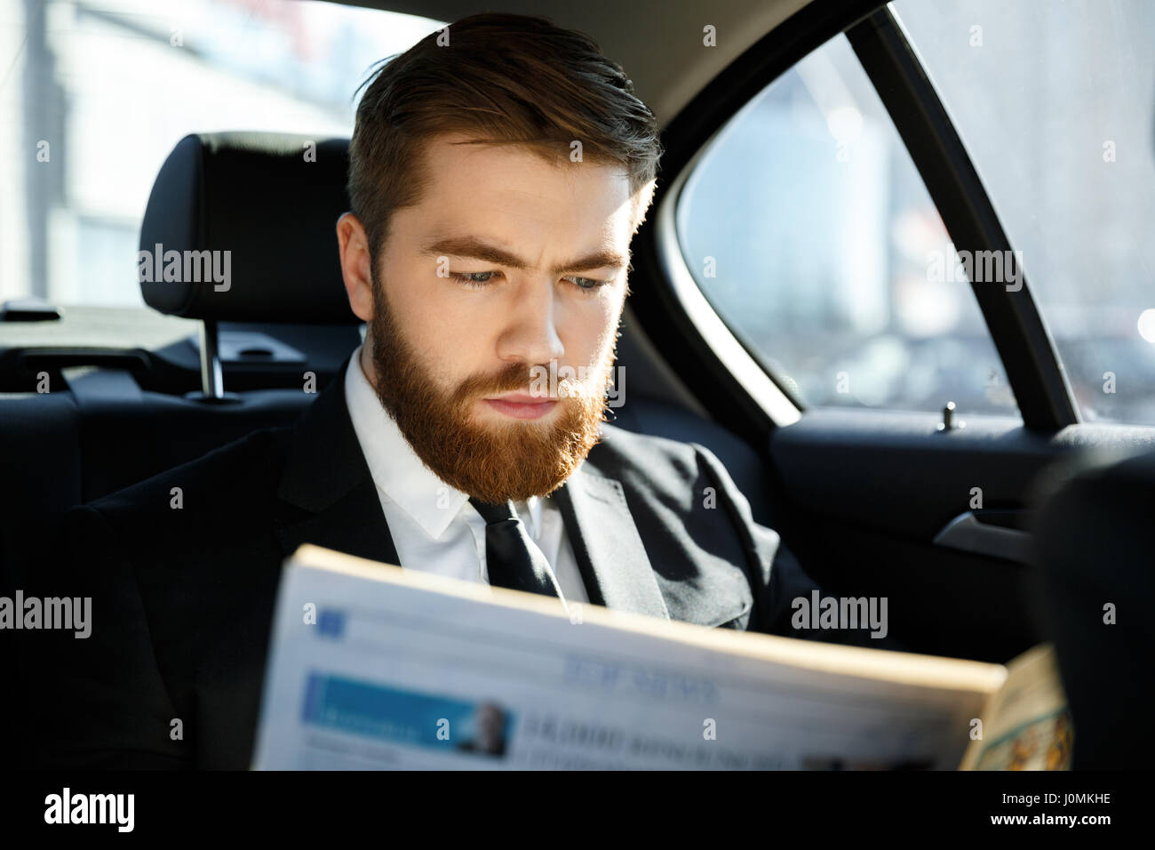 Businessman reading newspaper in car hi-res stock photography and ...