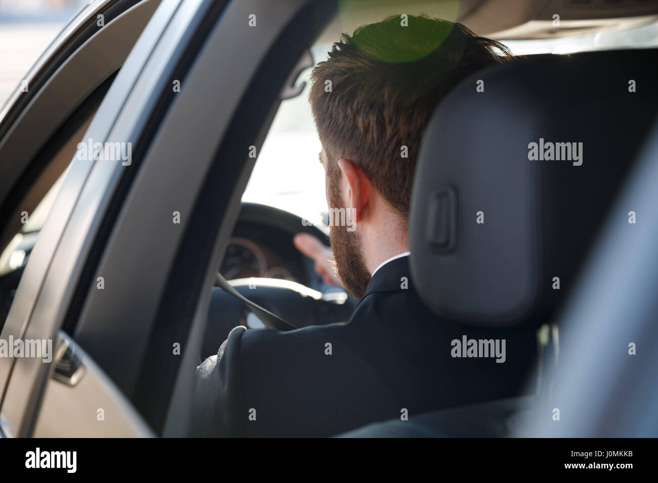 View from back of Bearded Business man in suit driving car Stock Photo ...