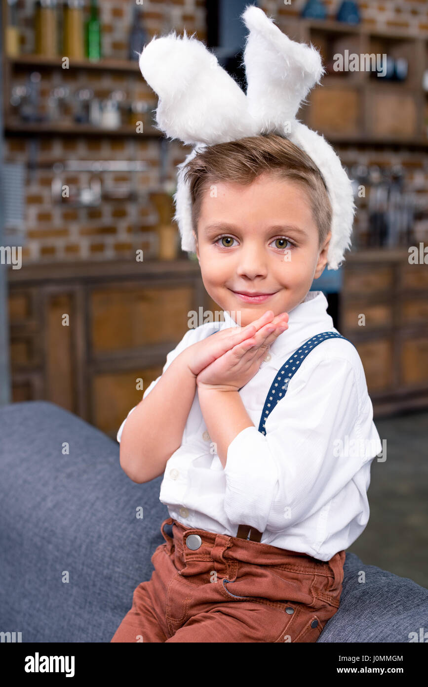 Cute little boy in bunny ears looking at camera and smiling Stock Photo ...