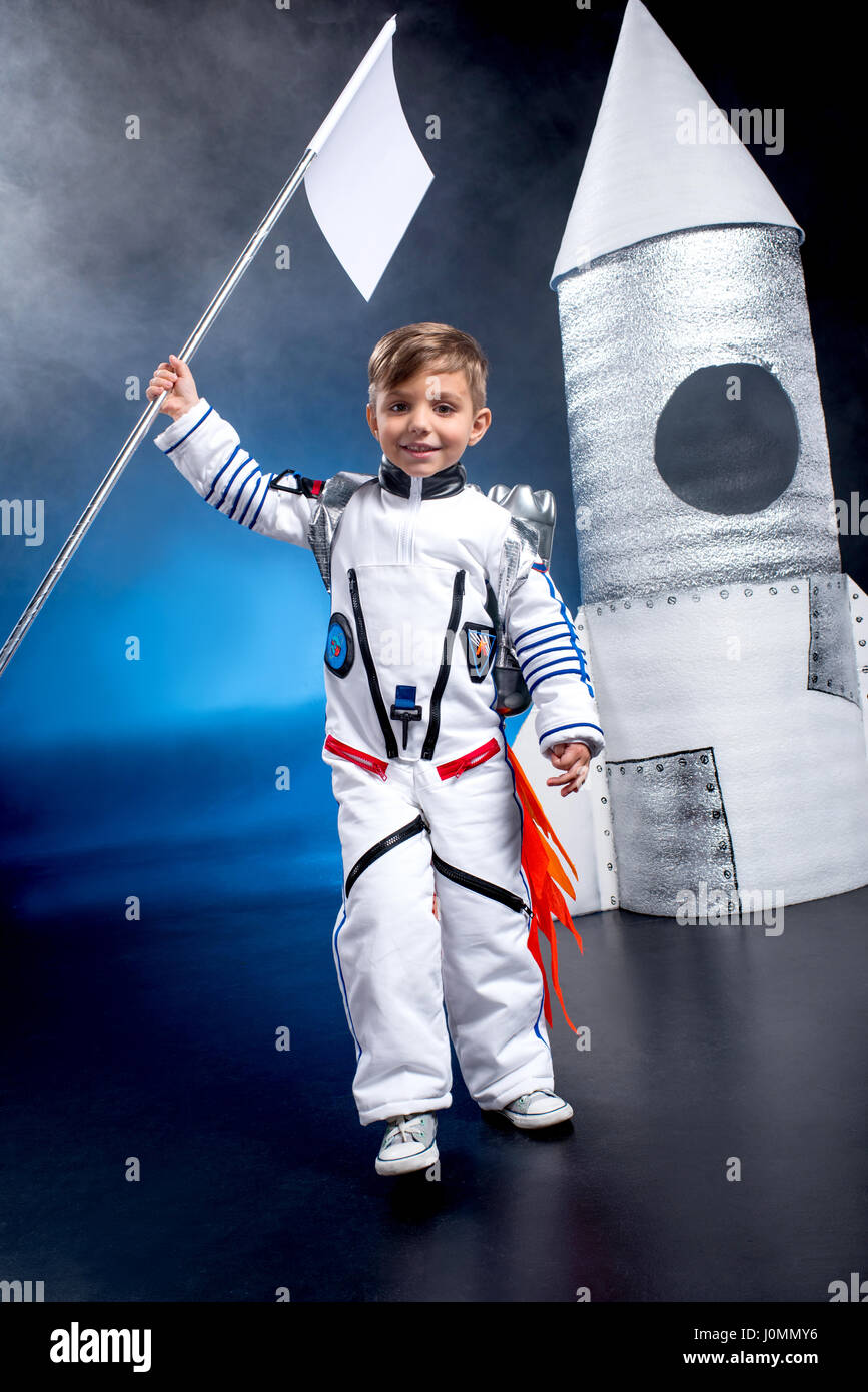 Little boy astronaut in space suit with flag standing near rocket Stock ...