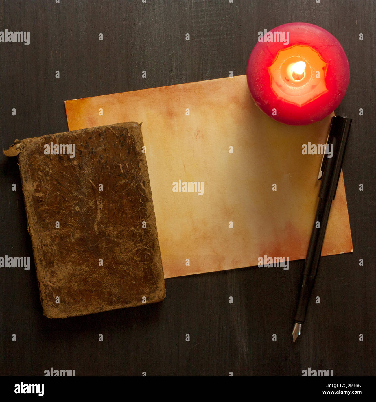 A square photo of a piece of old parchment on a black table, in the ...