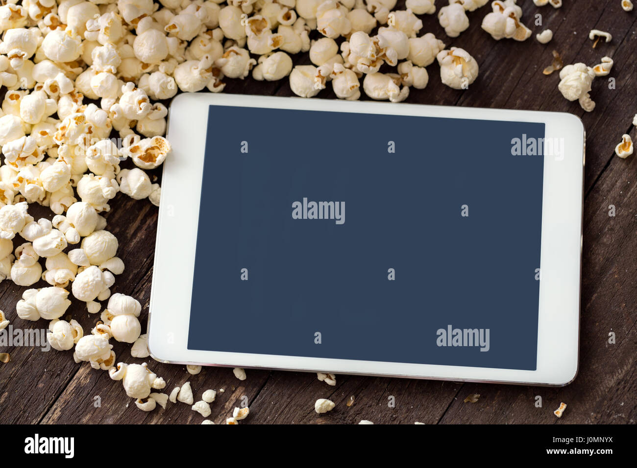 fresh popcorn with digital touch screen tablet Stock Photo - Alamy