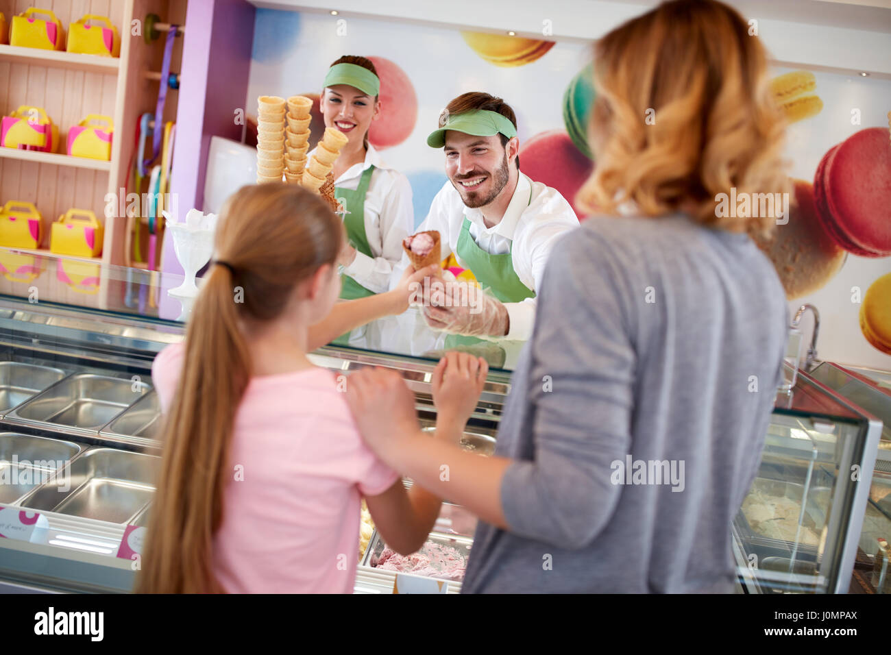 Kind shopkeeper in pastry shop gives ice cream to young girl Stock ...