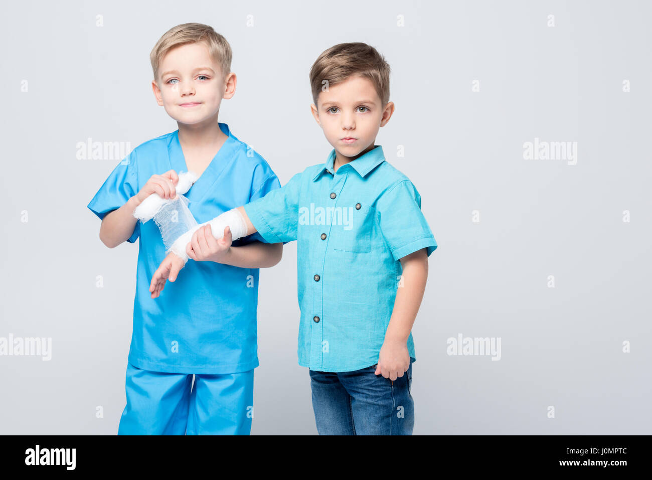 Little boy in doctor uniform bandaging hand of patient Stock Photo - Alamy