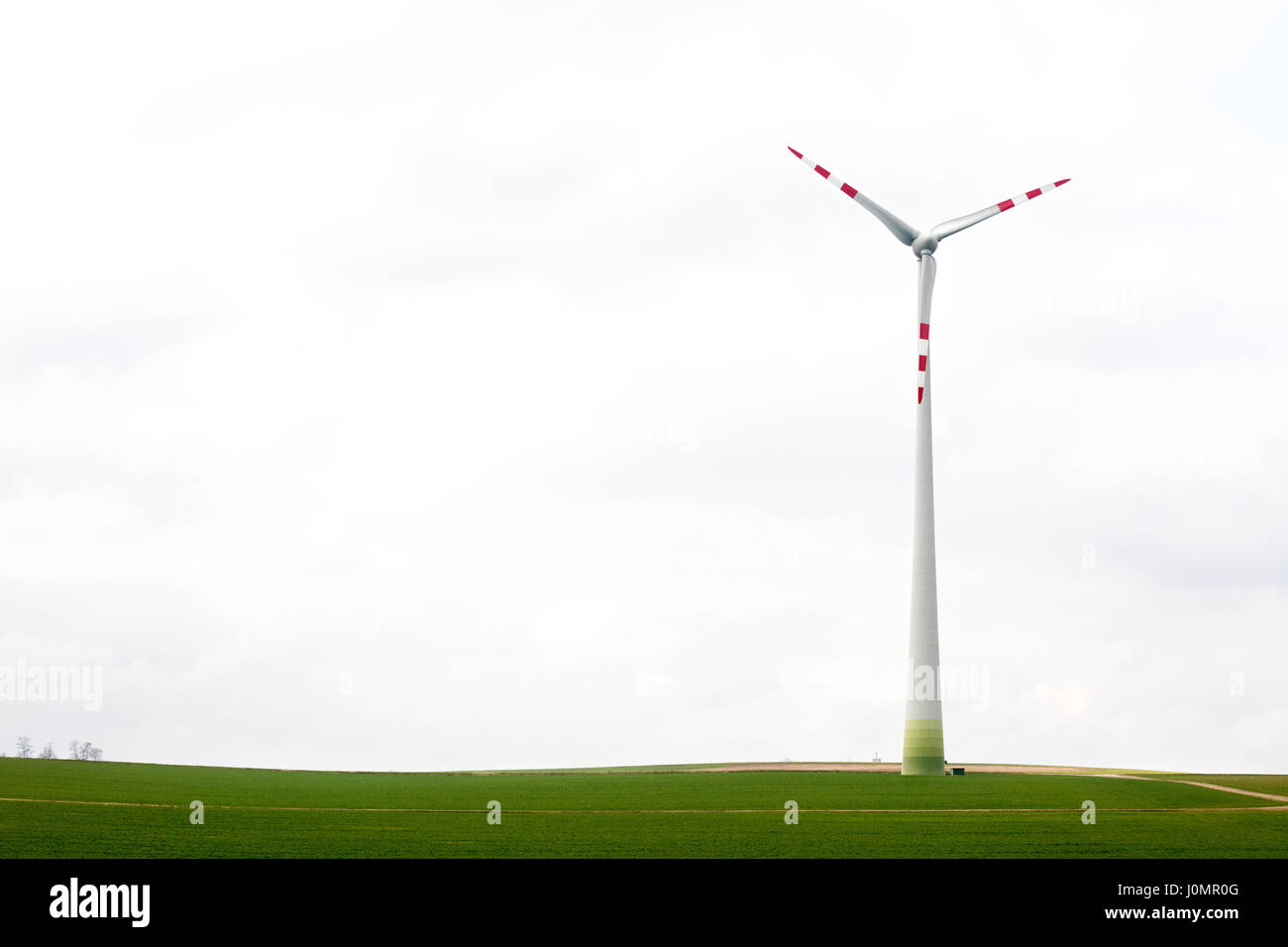 Windmill on a grassy field with clouds in background Stock Photo - Alamy