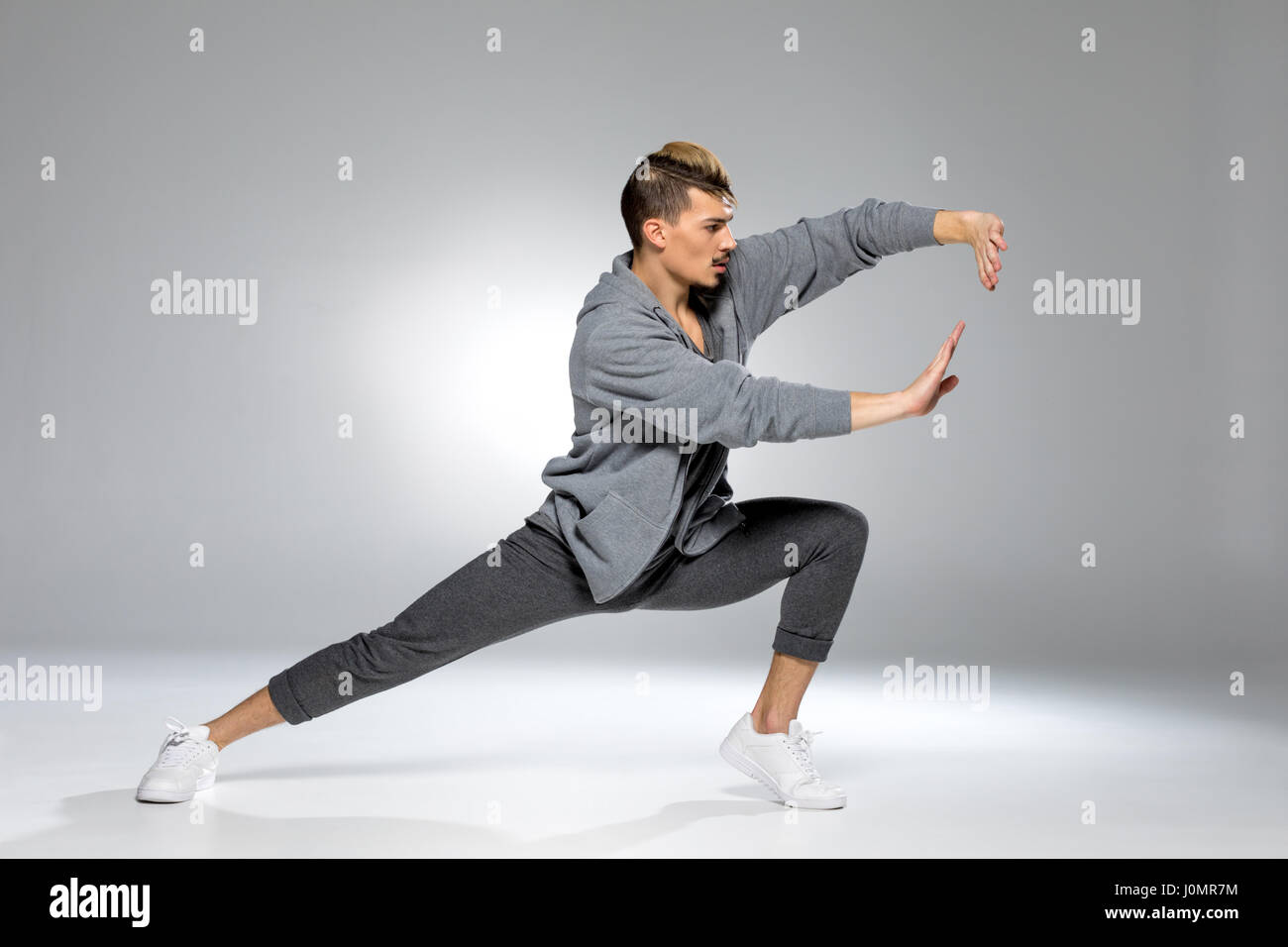 Handsome young male dancer in sportswear posing on white Stock Photo ...