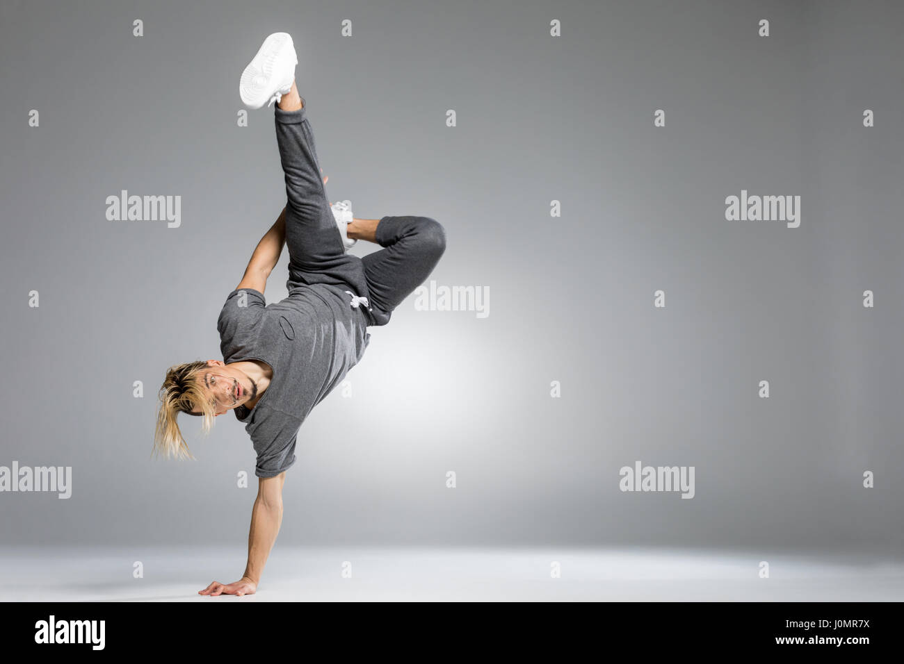 Handsome young man dancing while smiling at camera on white Stock Photo ...