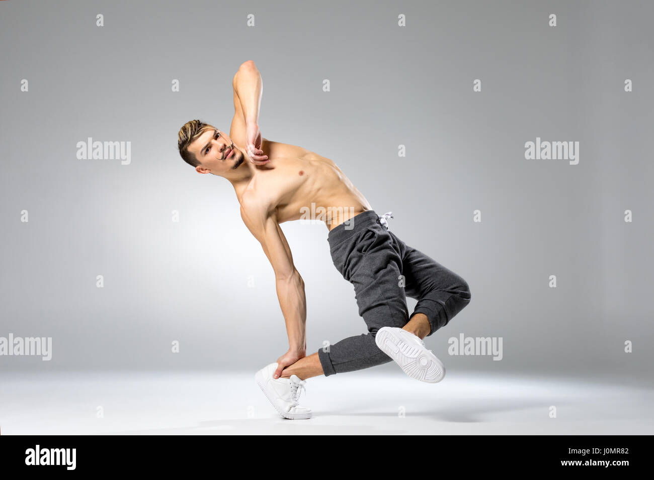 Young handsome shirtless man dancing and looking at camera Stock Photo ...