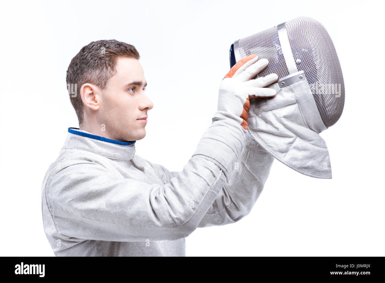 Side view of young man professional fencer wearing helmet on white ...