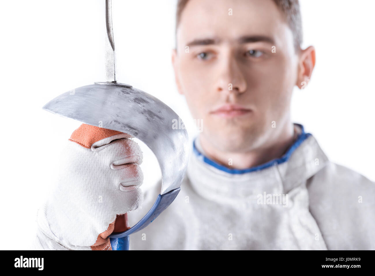 Close-up view of young man professional fencer holding rapier on white ...