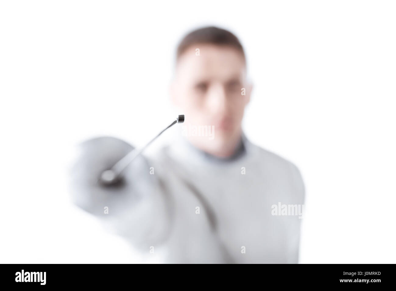 Close-up view of young man professional fencer holding rapier on white ...