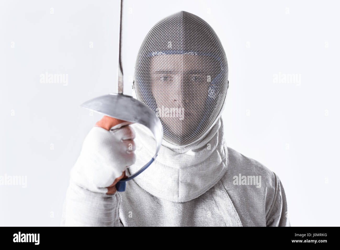 portrait of fencer in uniform holding rapier in hand on white Stock ...