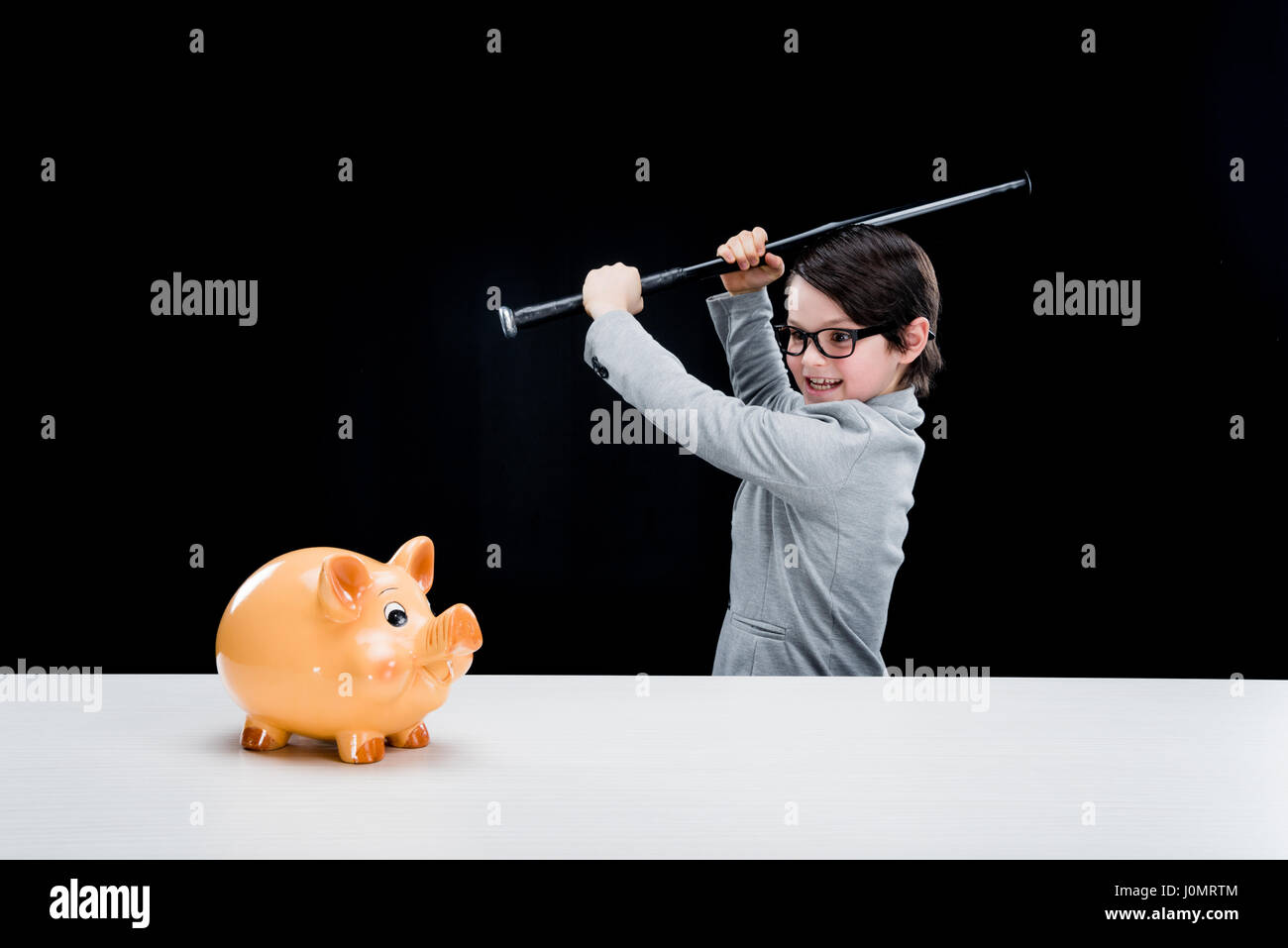 Little boy in formal suit holding baseball bat hitting piggy bank Stock ...