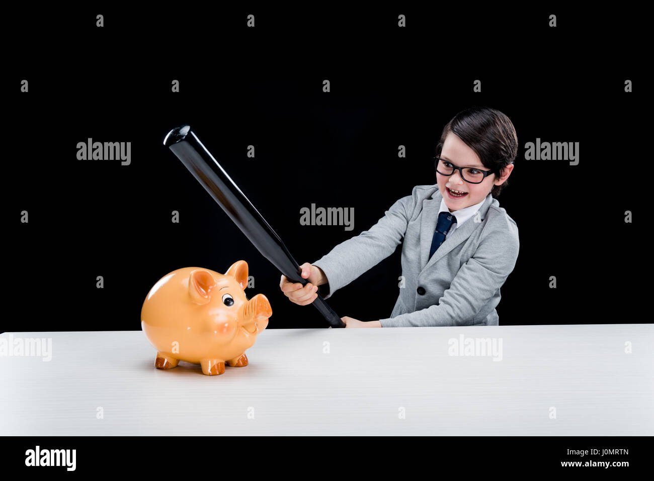 Little boy in formal suit holding baseball bat hitting piggy bank Stock ...