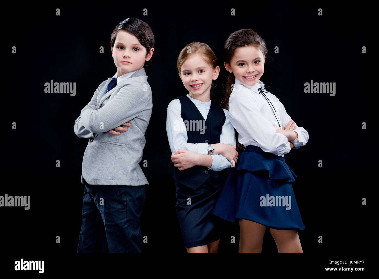 Children posing in business formalwear on black Stock Photo - Alamy
