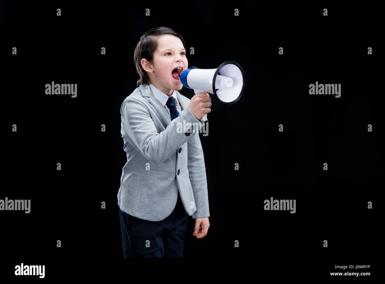 Angry Boy standing with megaphone and yelling on black Stock Photo - Alamy
