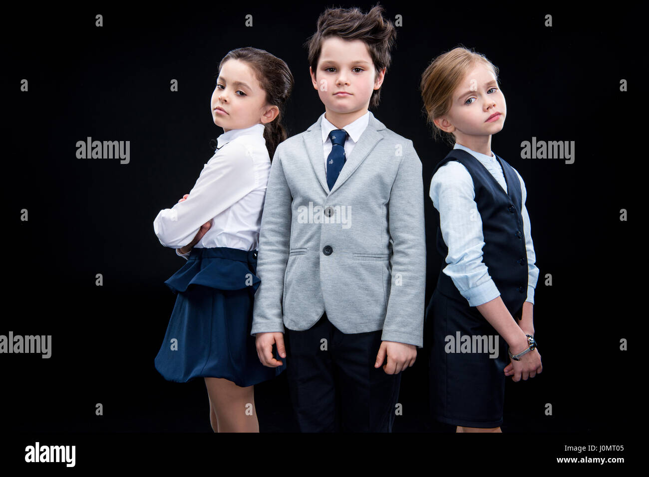 Children posing in business formalwear on black Stock Photo - Alamy