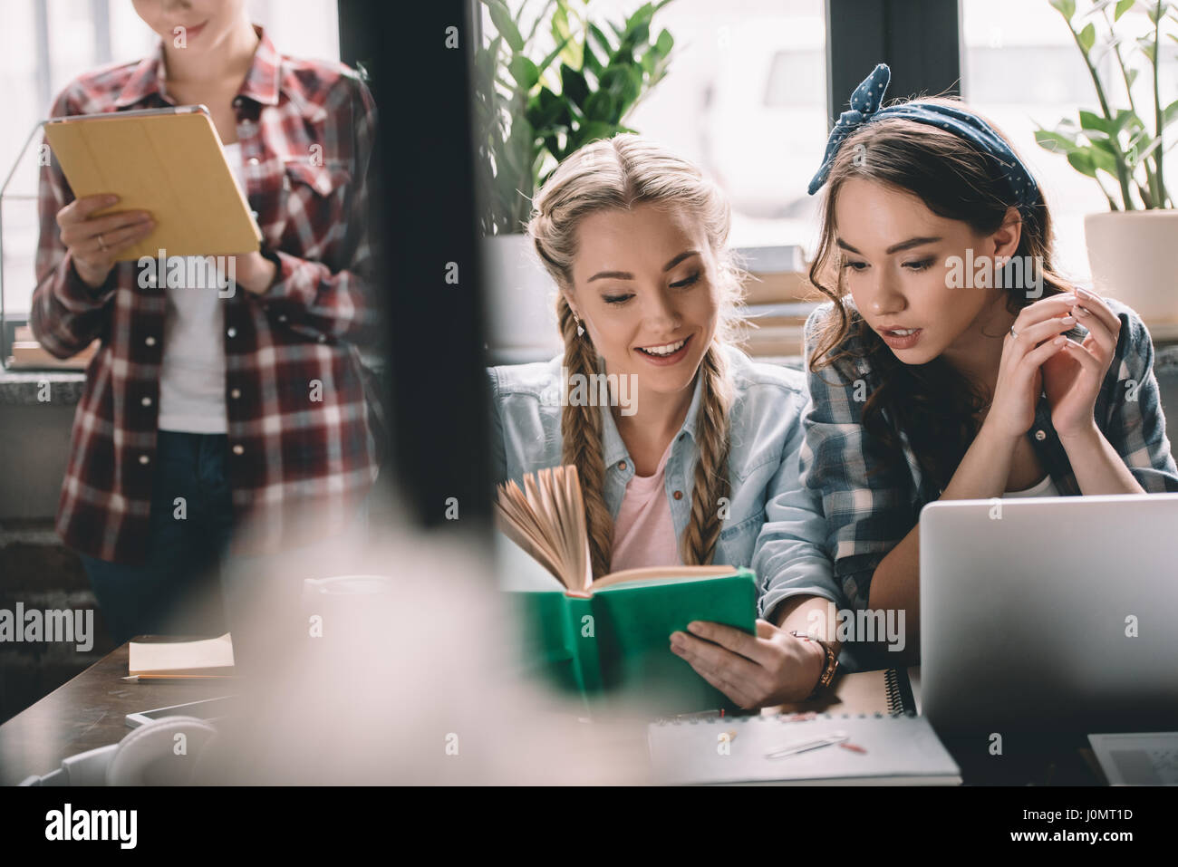 Young beautiful women students studying with devices and book Stock ...