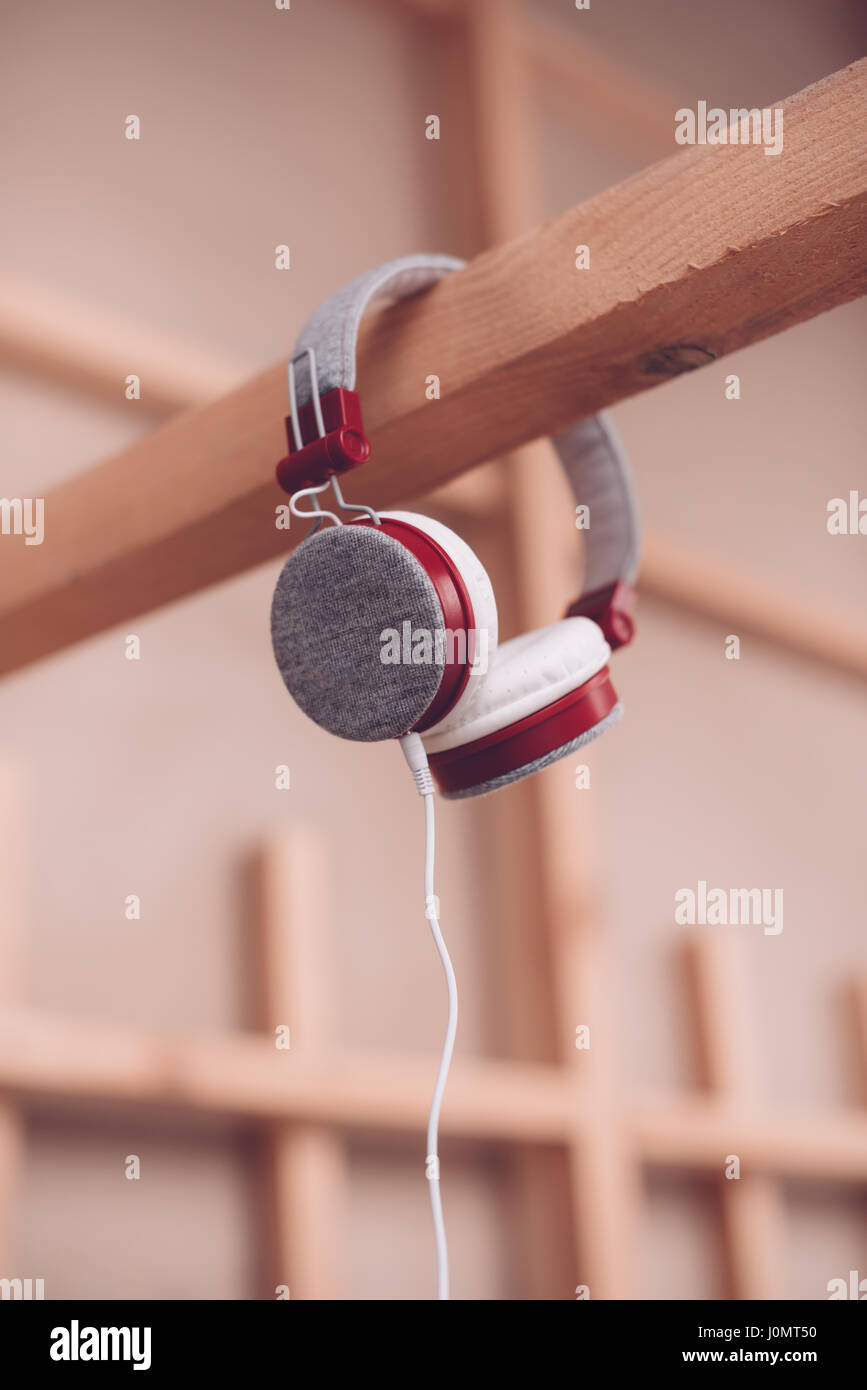 Modern plastic headphones with cable hanging on wooden beam Stock Photo ...