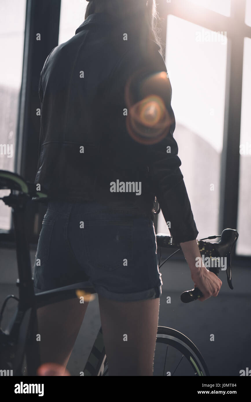 back view of young stylish woman riding bicycle Stock Photo - Alamy
