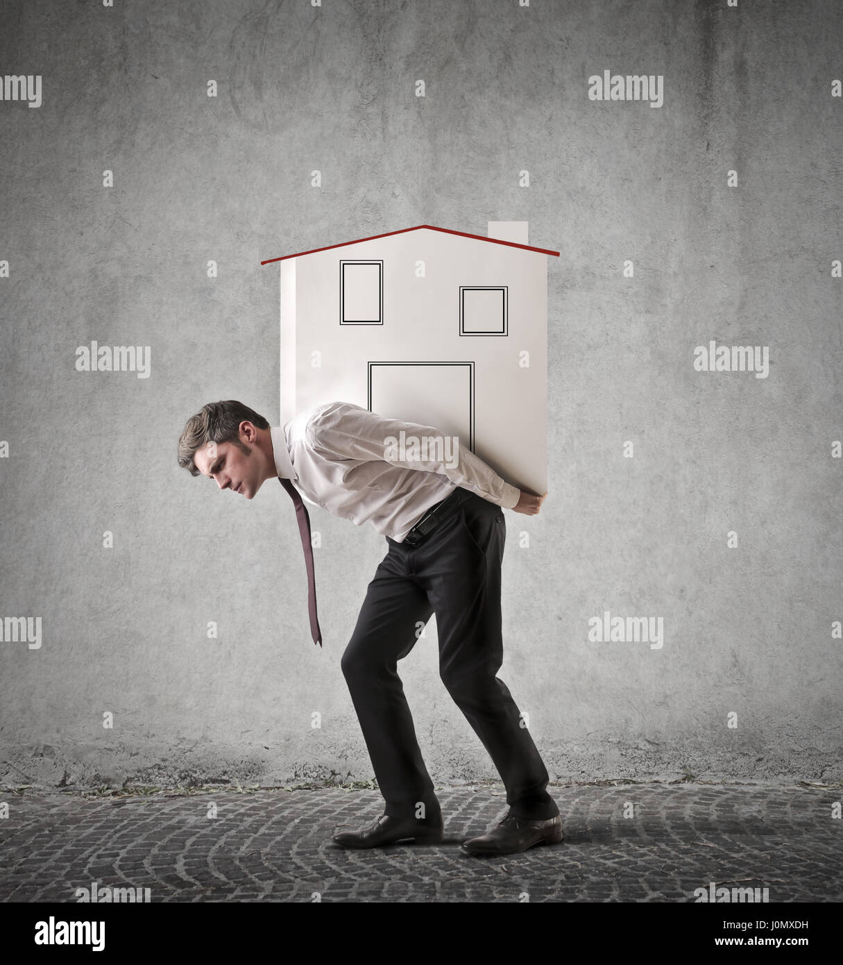 Businessman carrying heavy home Stock Photo - Alamy