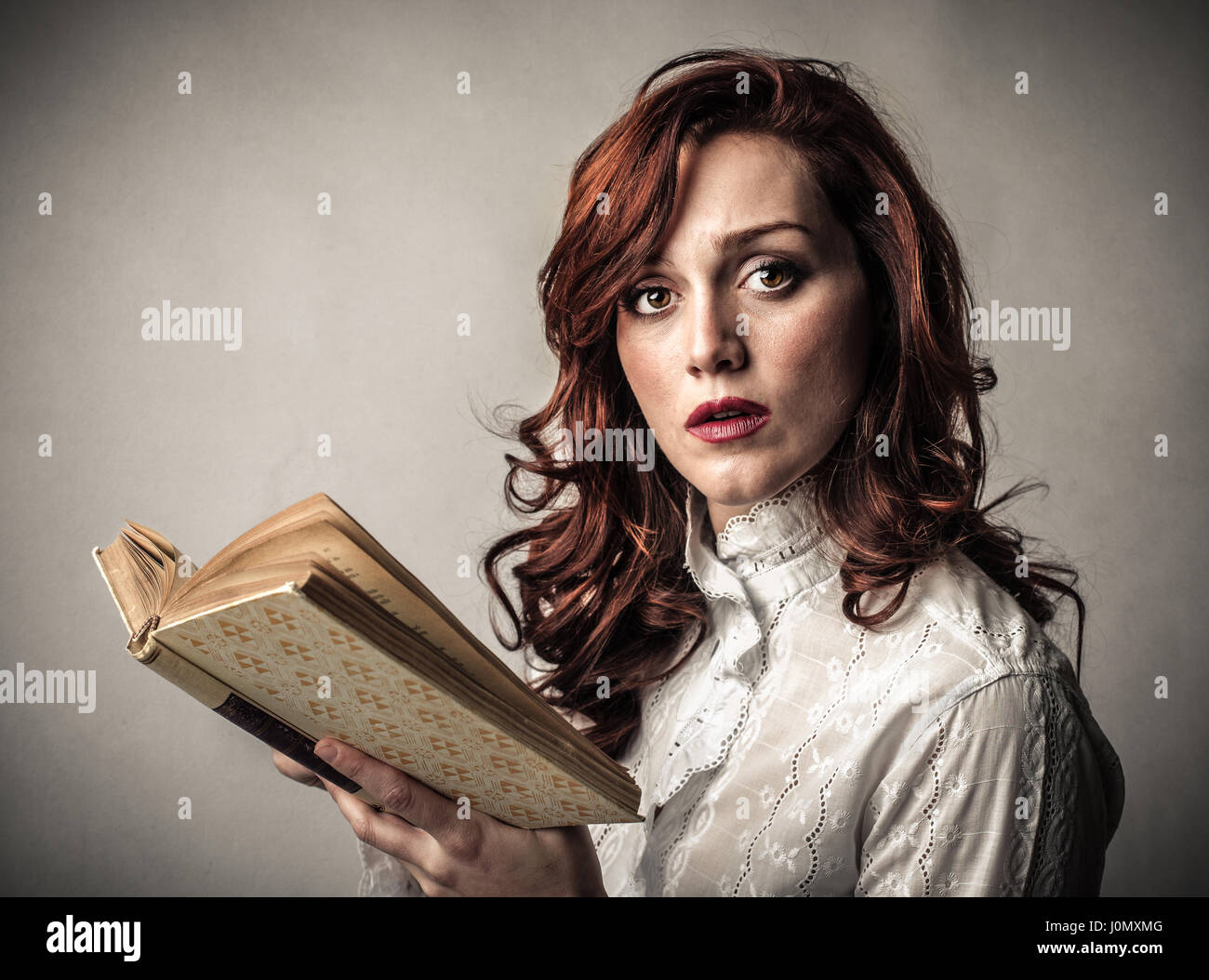 Woman reading from book Stock Photo - Alamy