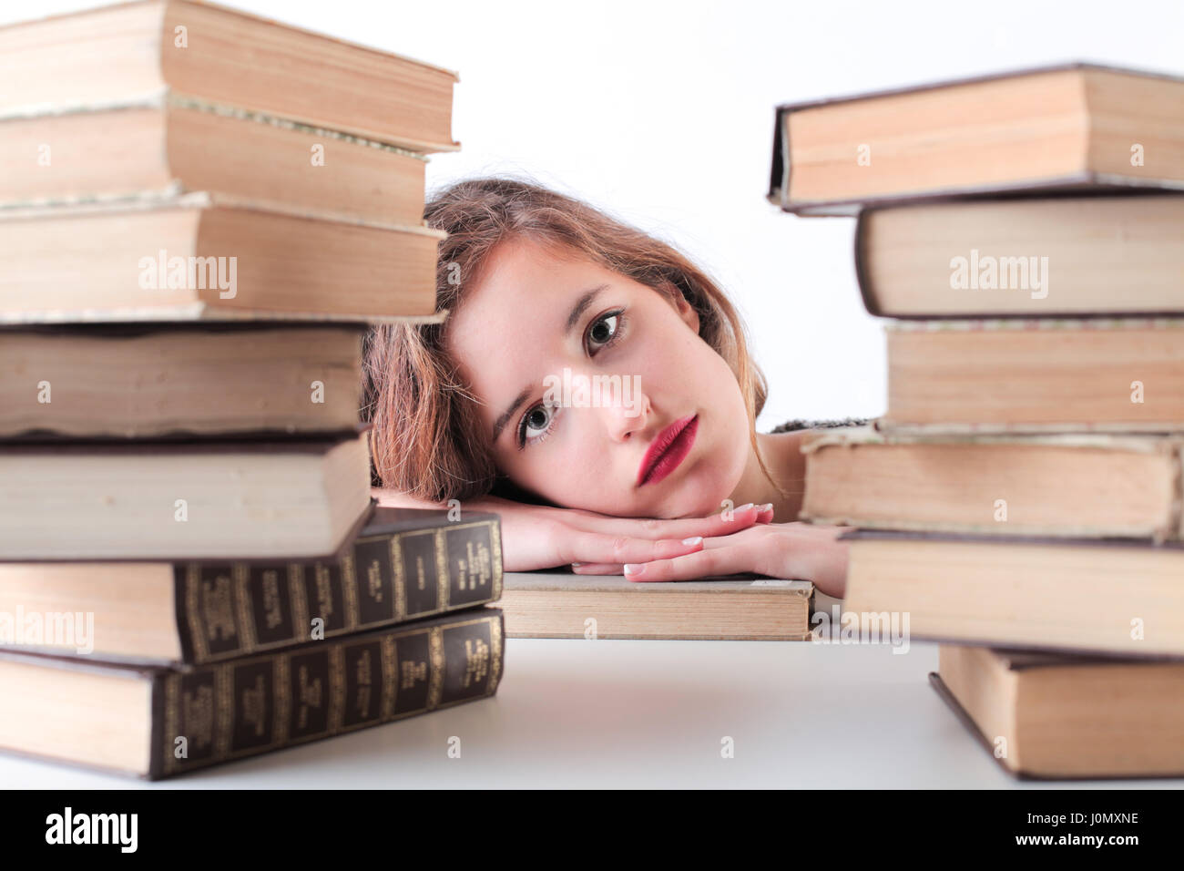 Tired student woman reading from books Stock Photo - Alamy