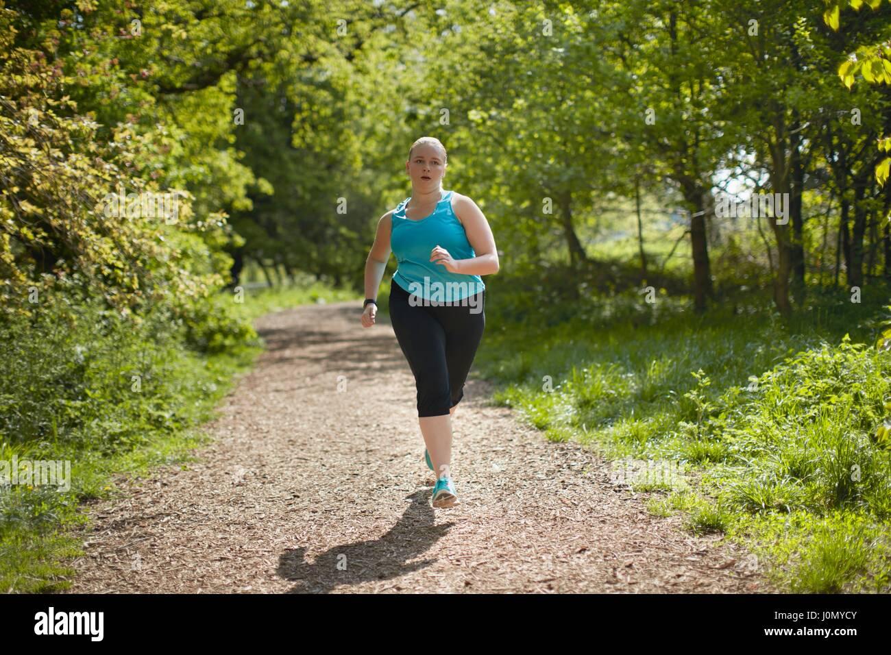 Young woman running on path Stock Photo - Alamy