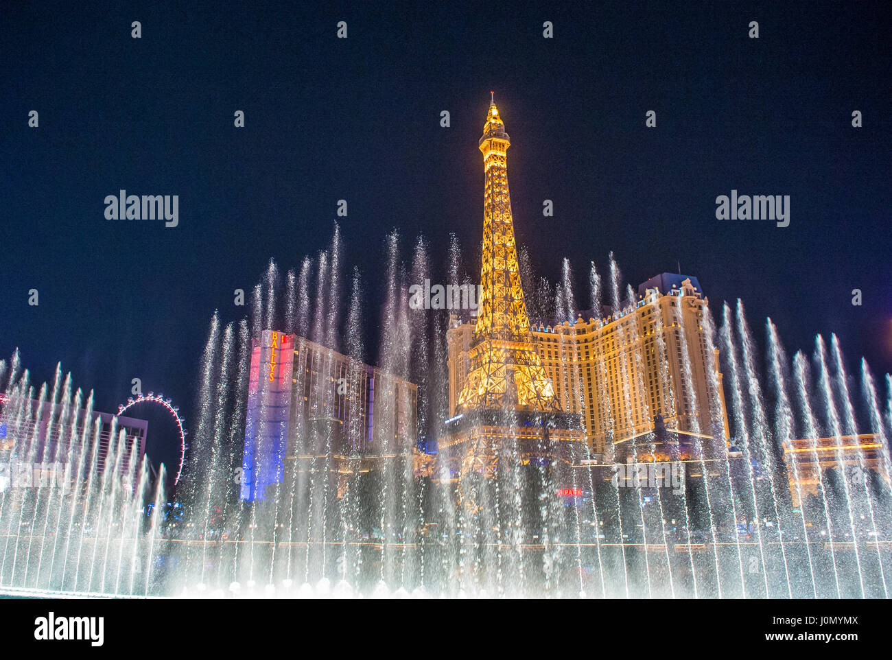 Night view of the dancing fountains of Bellagio and the Eiffel Tower ...