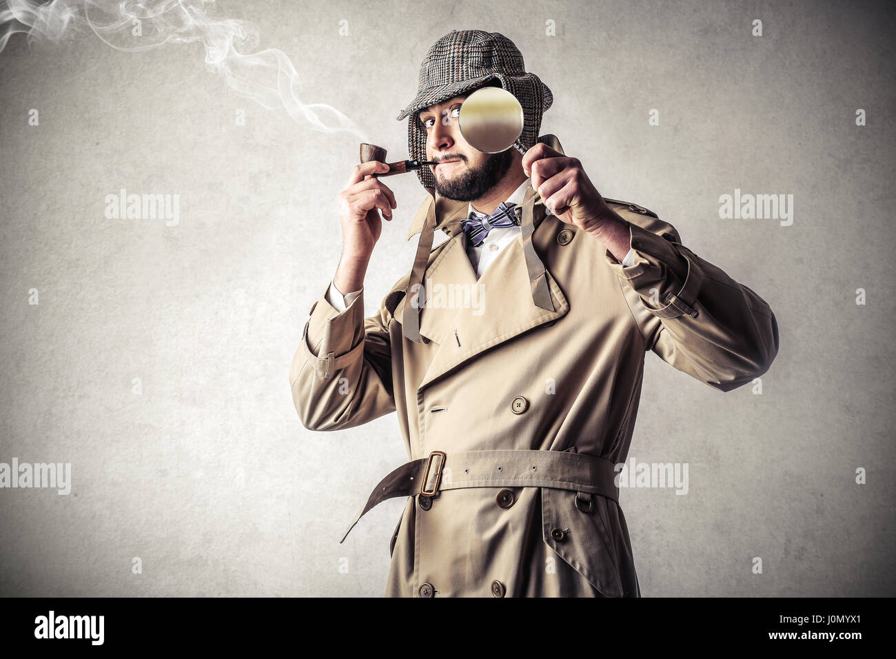 Investigator man smoking on pipe Stock Photo - Alamy