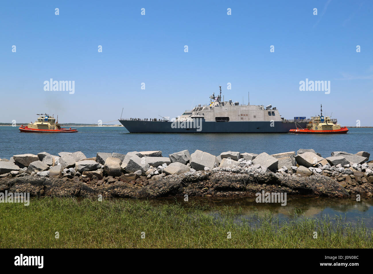 USS Milwaukee (LCS-5) being towed into the harbor basin at NS Mayport ...