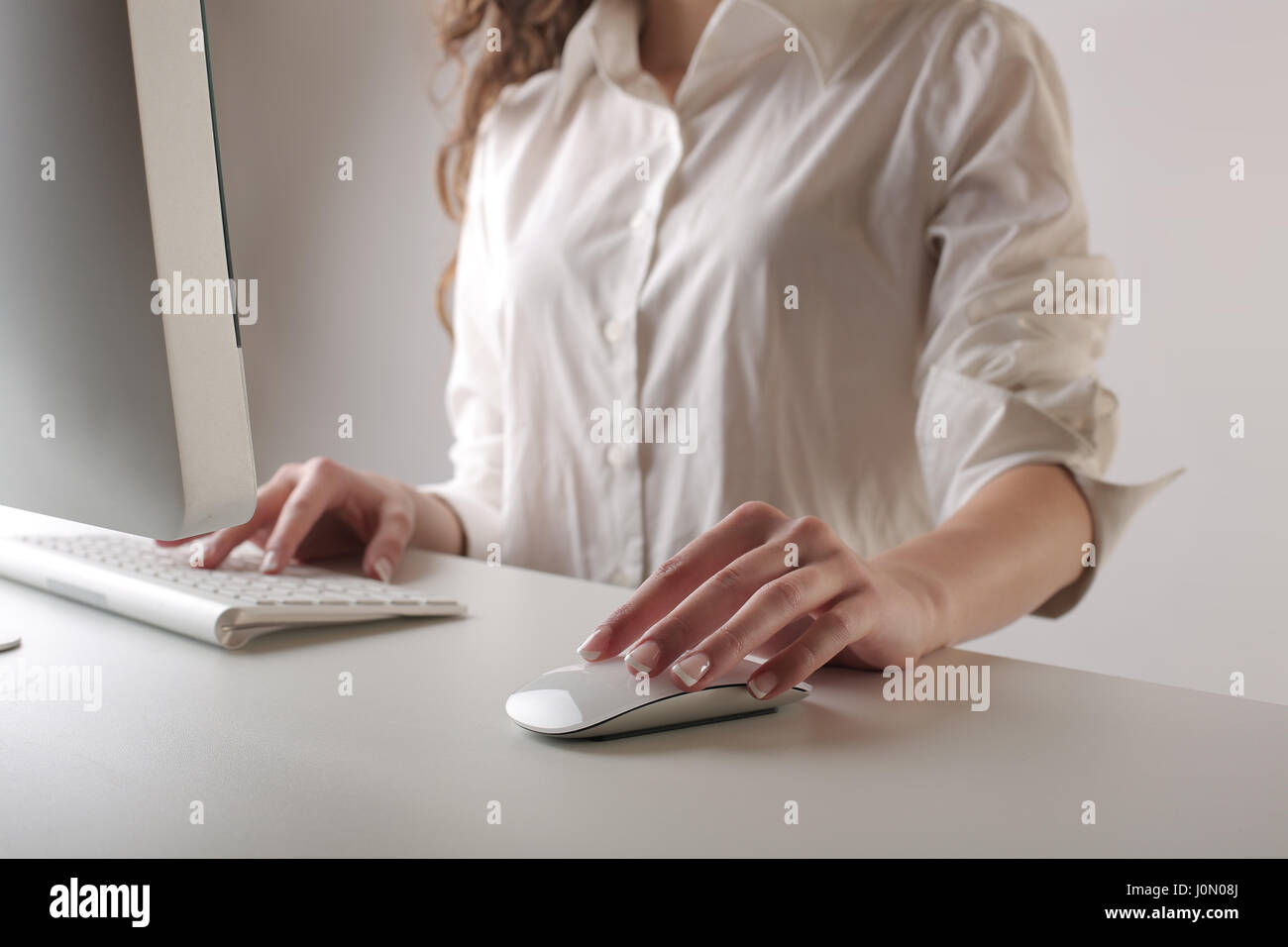 Blond woman working on computer Stock Photo - Alamy