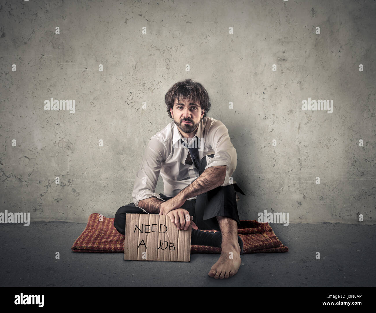 Homeless man sitting on the street Stock Photo - Alamy