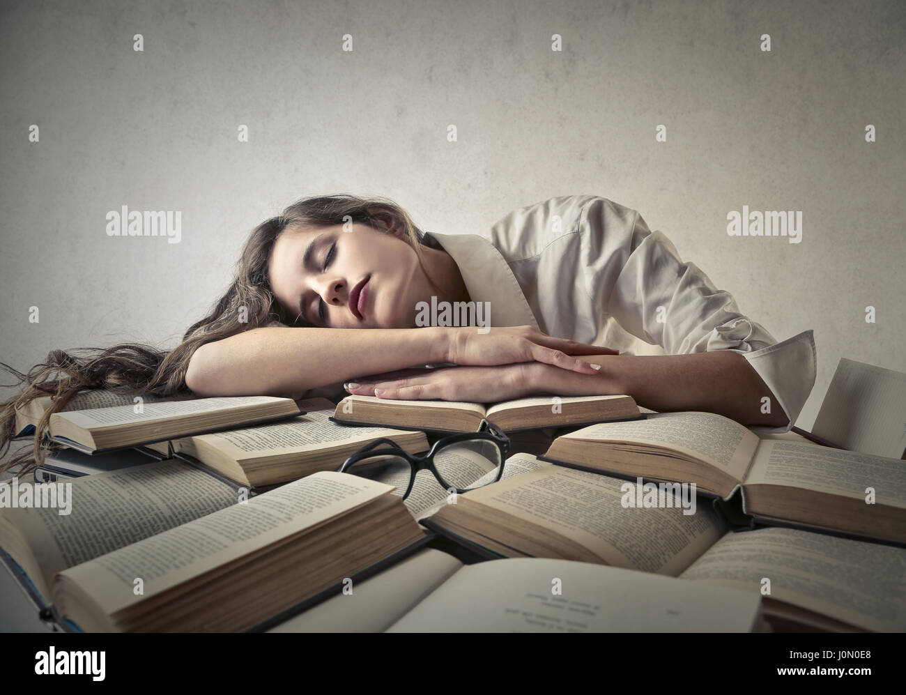 Woman sleeping on books Stock Photo - Alamy