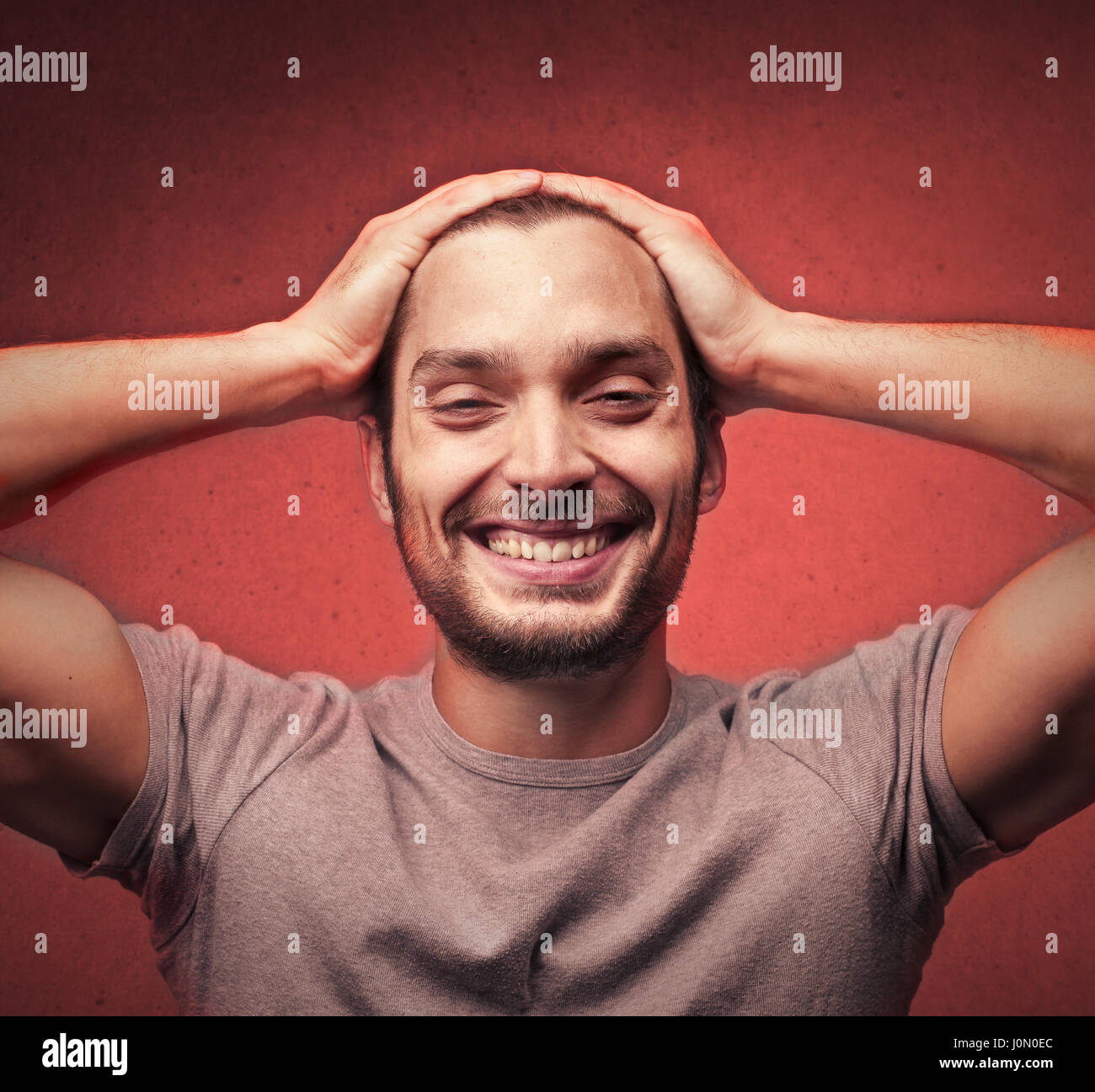 Happy man holding his head Stock Photo - Alamy