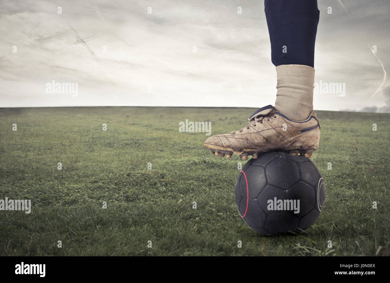 Foot standing on soccer ball Stock Photo - Alamy