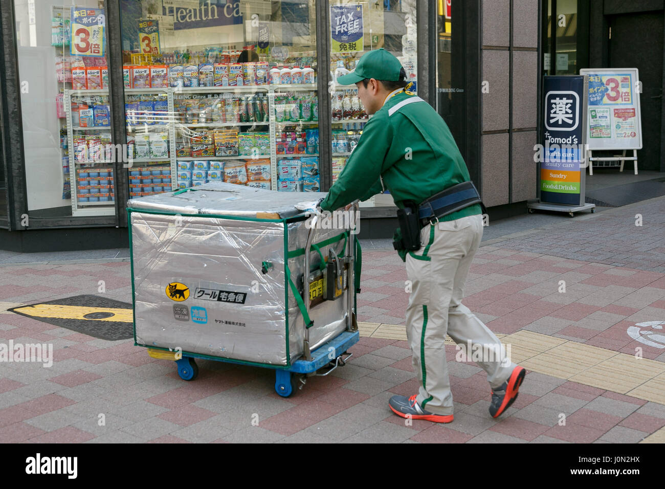 Tokyo, Japan. 14th April, 2017. A Yamato Transport worker pushes a ...