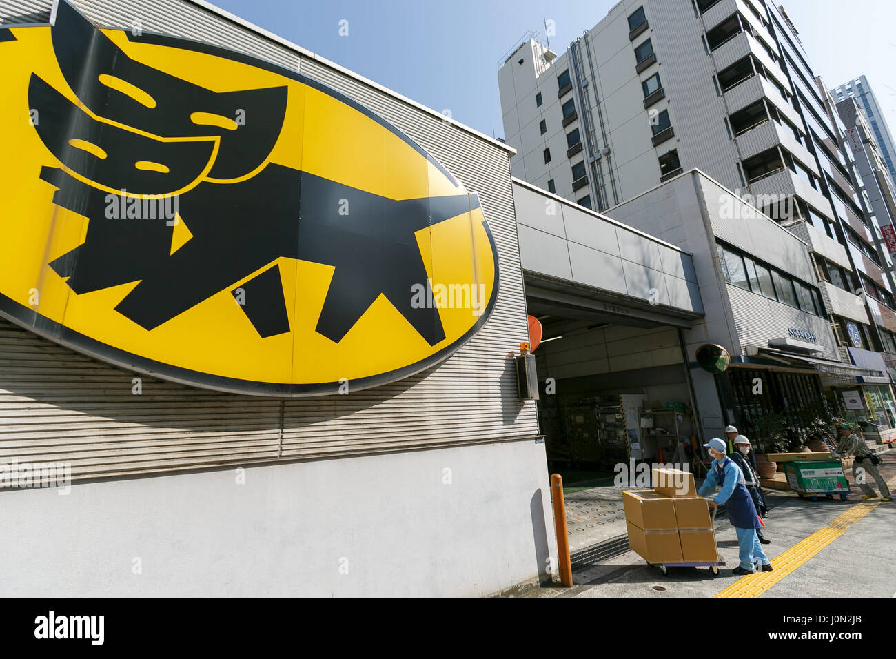 Tokyo, Japan. 14th April, 2017. Yamato Transport workers push trolleys ...