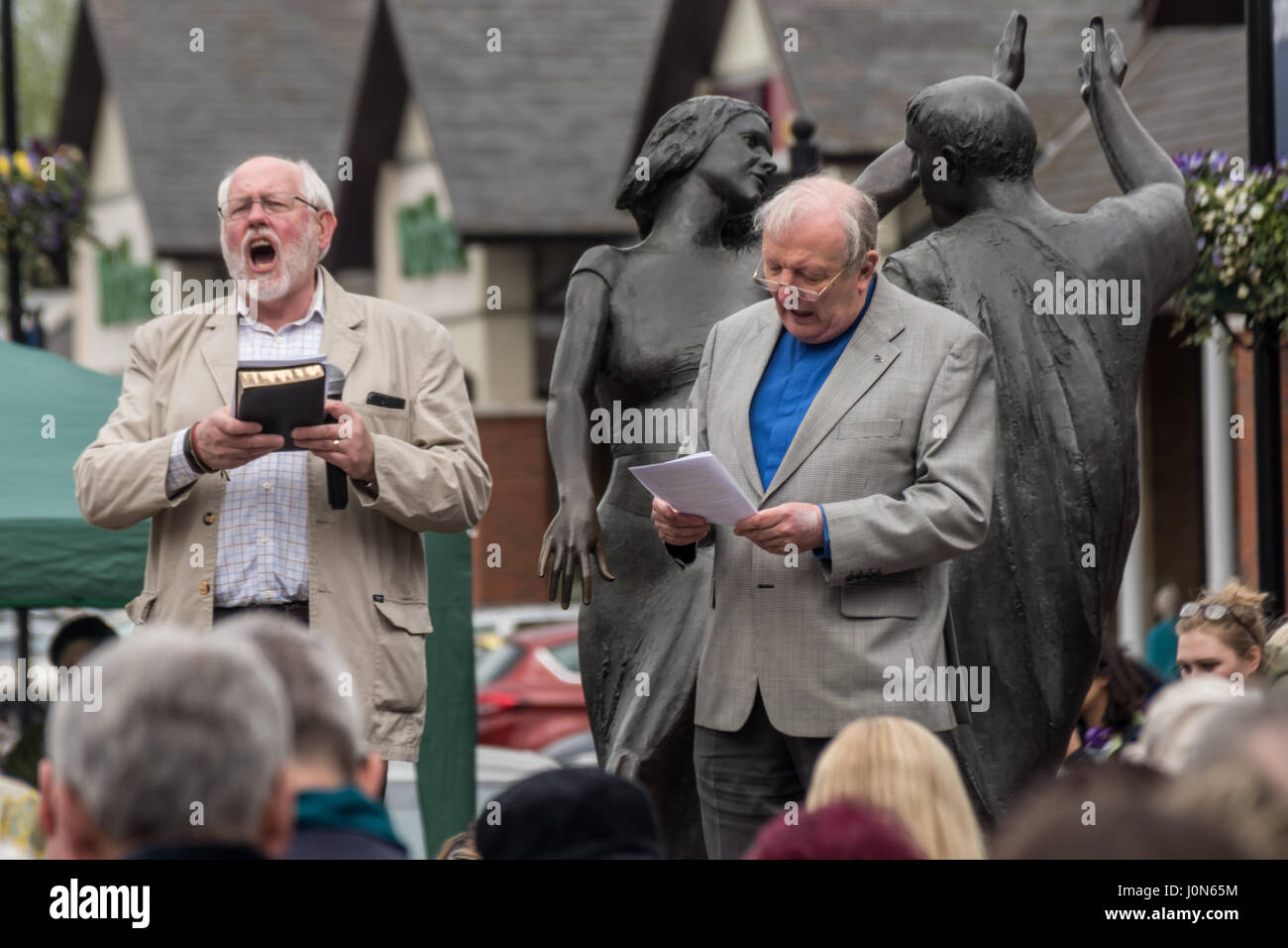 London, UK. People sing a hymn next to the statues of the two dancers ...