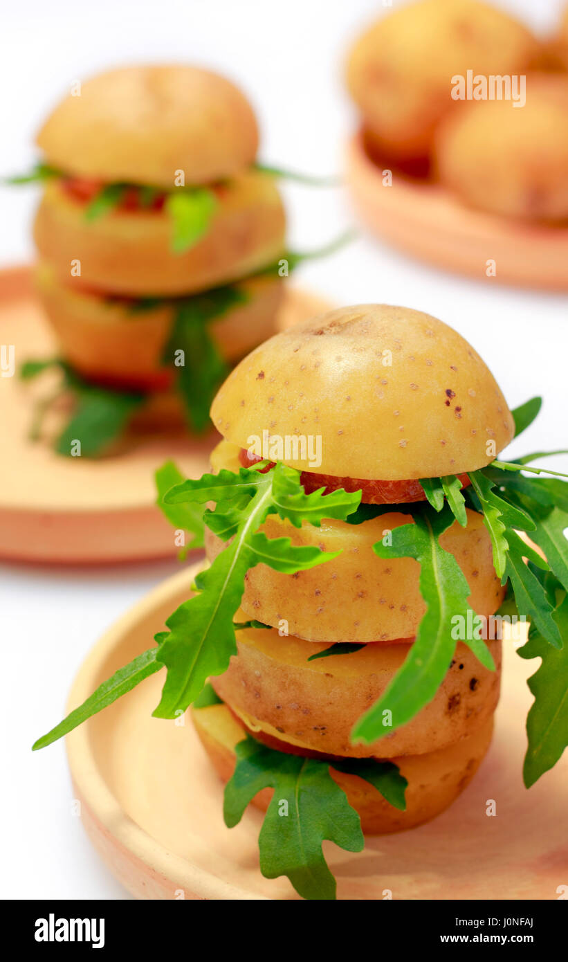Boiled and sliced potato towers with rocket Stock Photo - Alamy