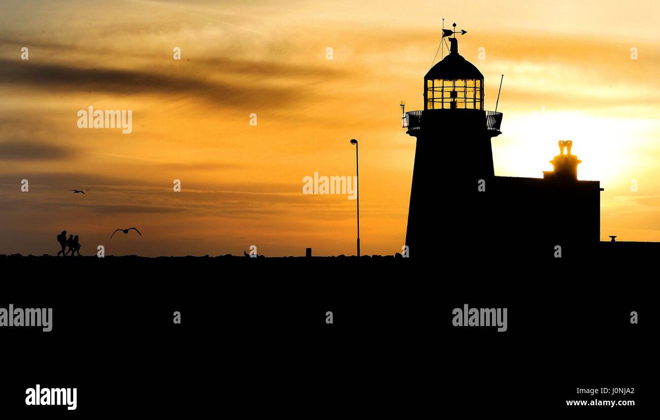 People go for an early morning walk along Howth pier, Dublin, as the ...