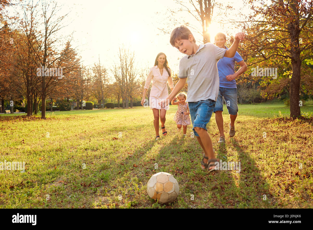 Family playing with a ball in the park Stock Photo - Alamy