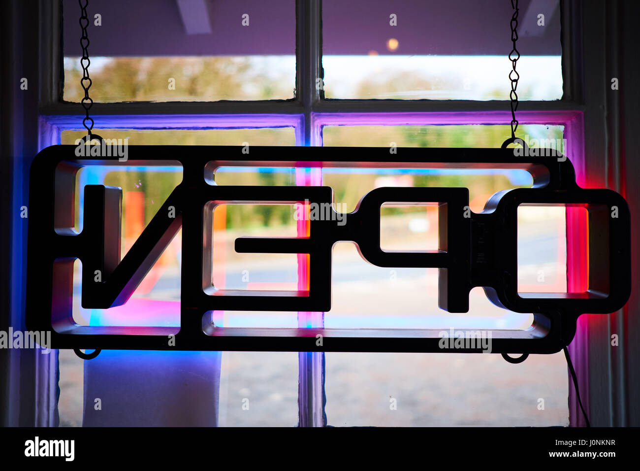 Lit up neon multicoloured Open sign hung in diner window seen from ...