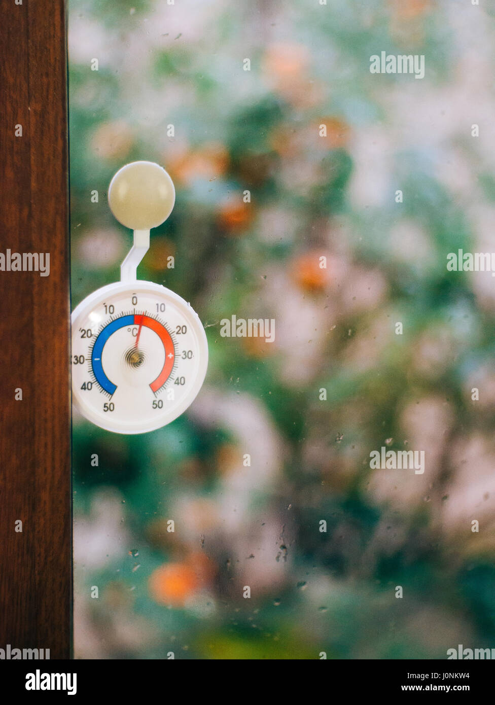 Round thermometer on the window. 5 degrees Celsius. The snow outside ...