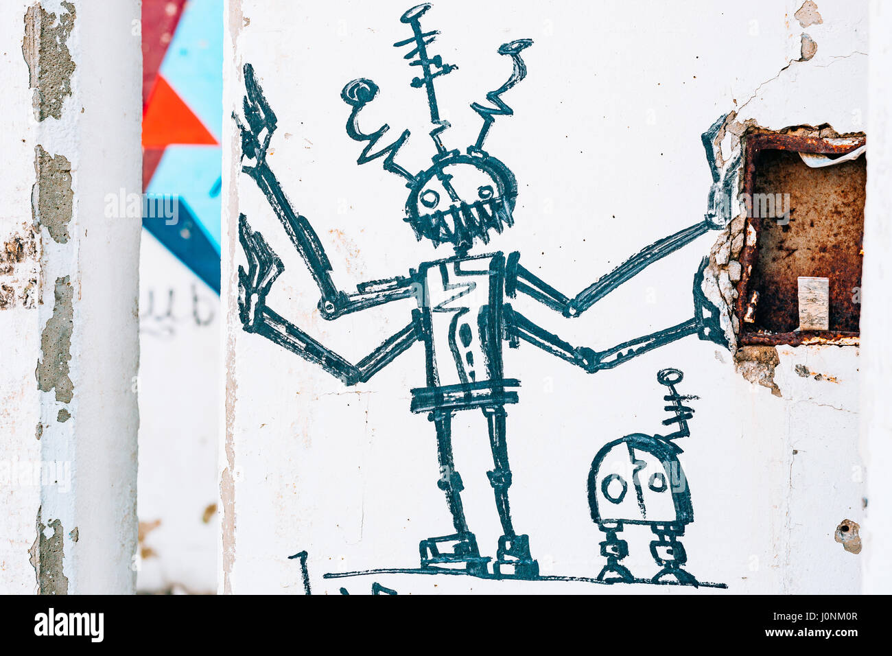 A simple drawing of a robot on a white wall. Four-armed robot with ...