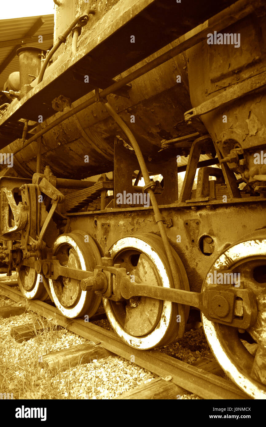 Closeup of antique rusty broken steam locomotive standing on rails ...